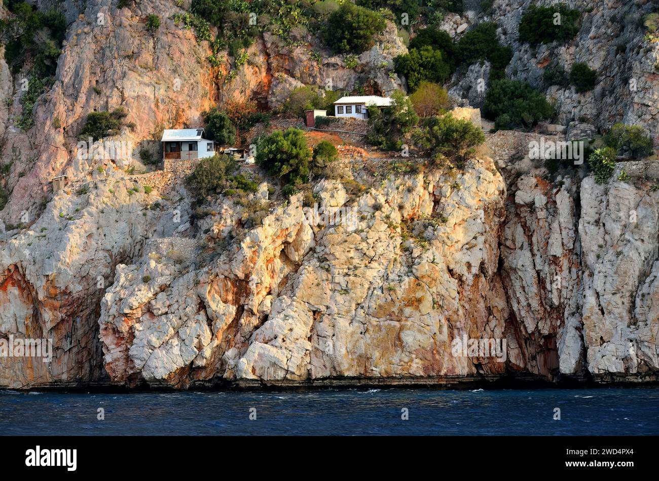 Boat sailing near houses and cliff on the ocean Stock Photo - Alamy