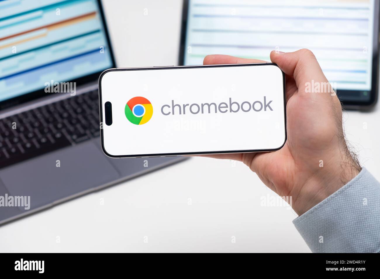 Chromebook logo of app on the screen of mobile phone held by man in ...