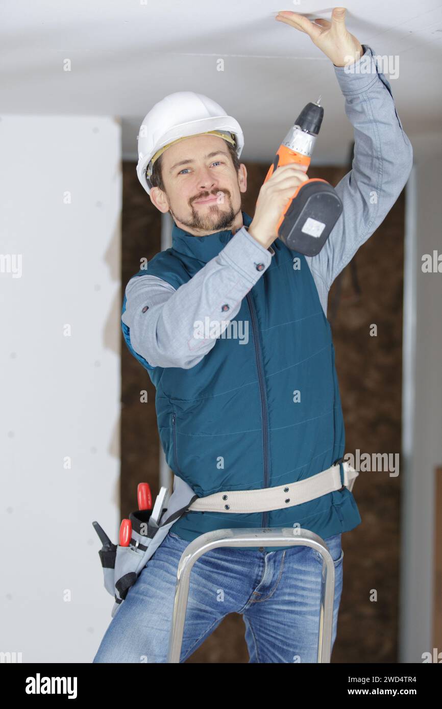 construction worker drilling in the ceiling Stock Photo - Alamy