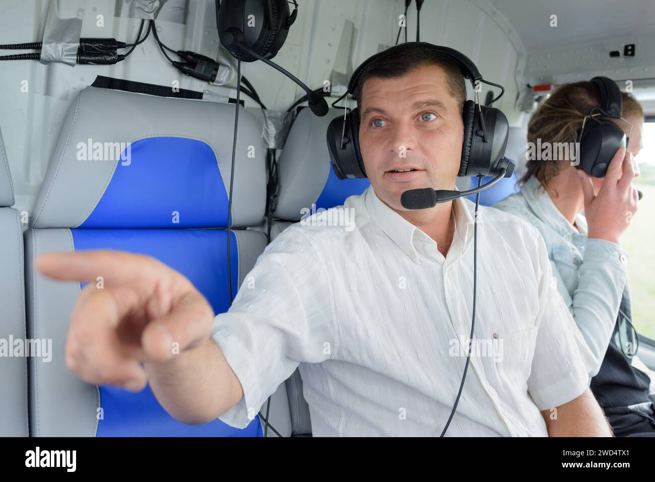 couple in aircraft man pointing out of window Stock Photo - Alamy