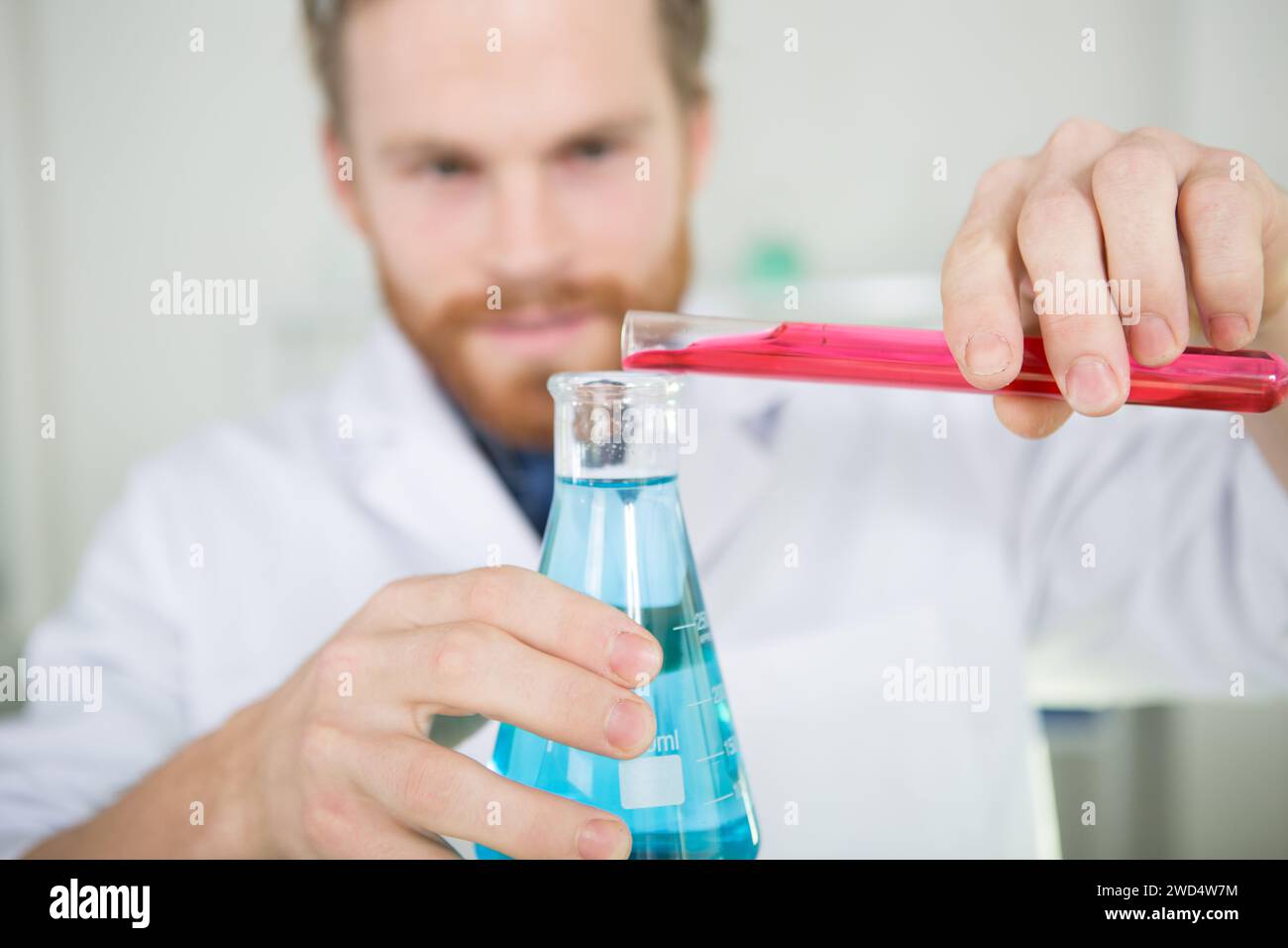 Male scientist pouring liquid hi-res stock photography and images - Alamy