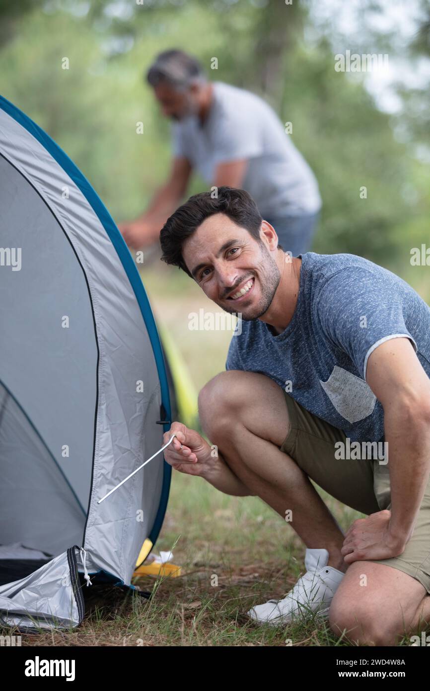 hiking man setting up a tent Stock Photo - Alamy