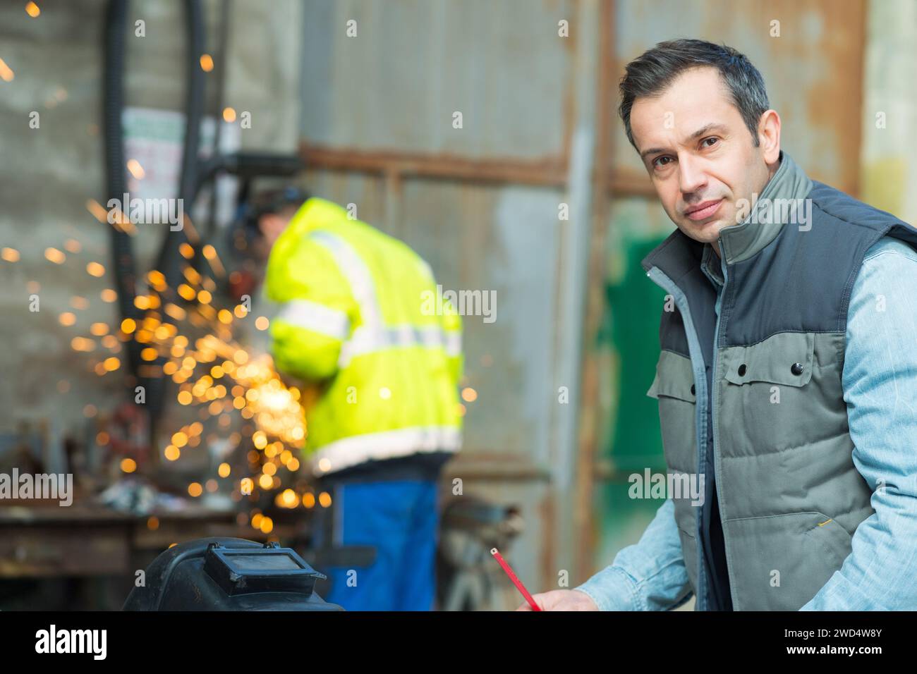 portrait of male worker sparks from grinder in background Stock Photo ...