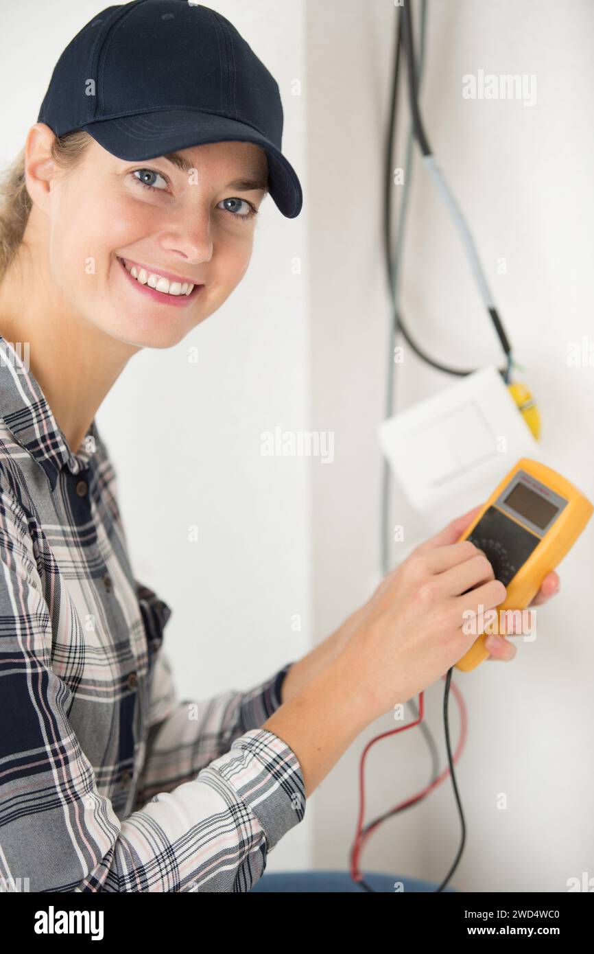 happy female electrician testing a wall socket Stock Photo - Alamy