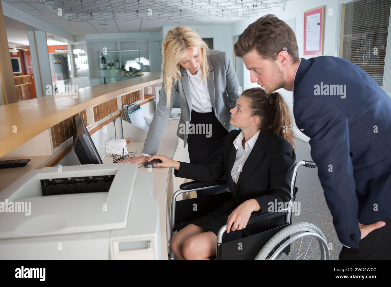 female in wheelchair working in a reception of a hotel Stock Photo - Alamy