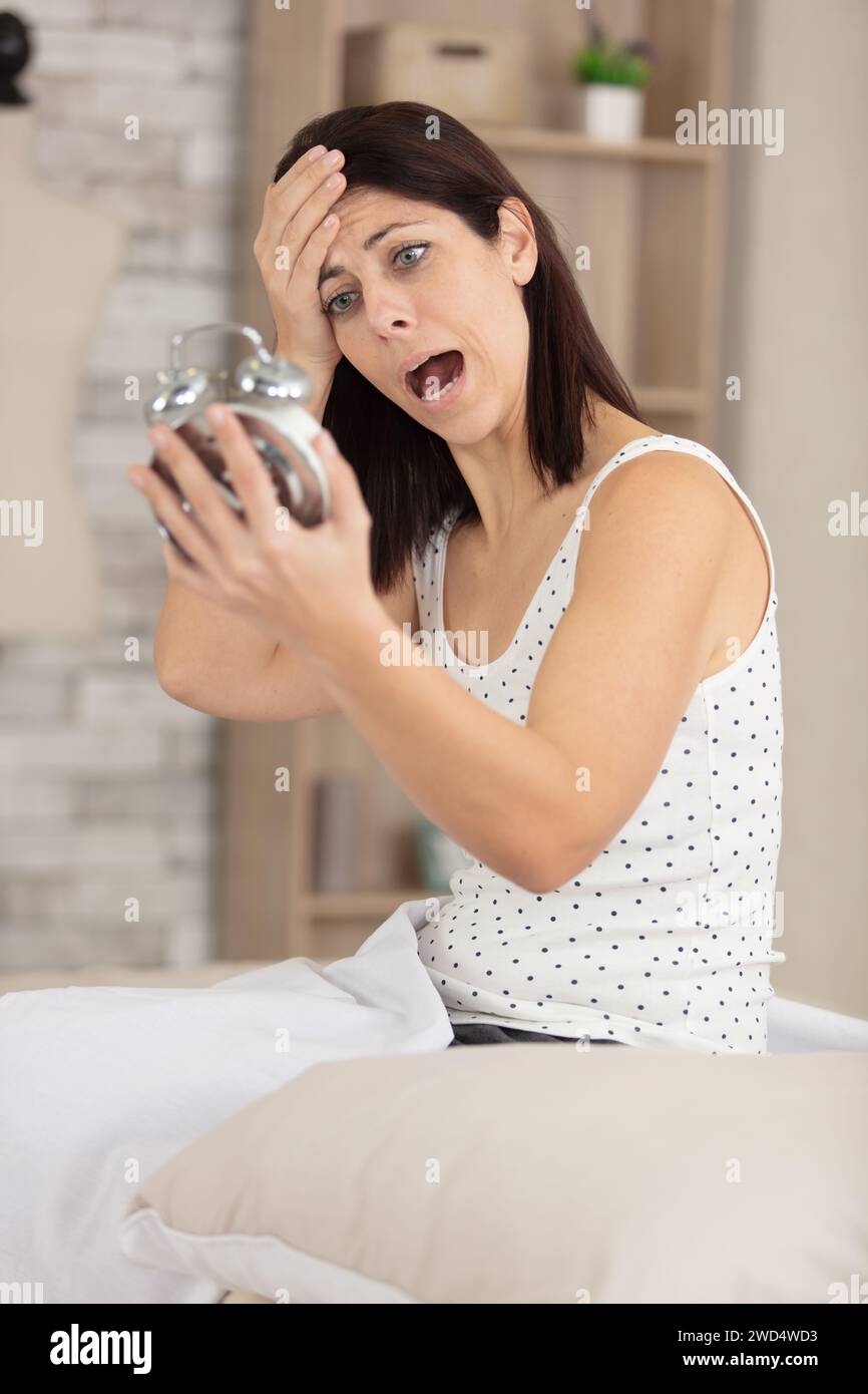 shocked young woman waking up with alarm Stock Photo - Alamy