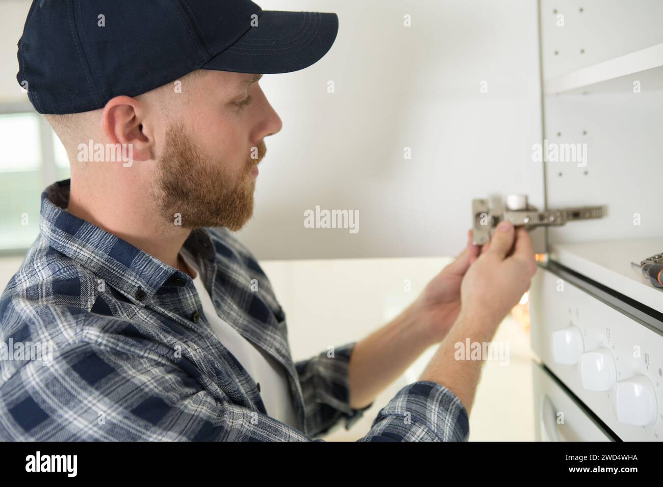 repairman fixing a cabinet door Stock Photo - Alamy