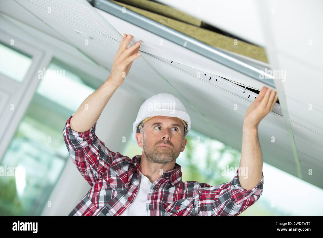 man in builder uniform hand up installing suspended ceiling Stock Photo ...