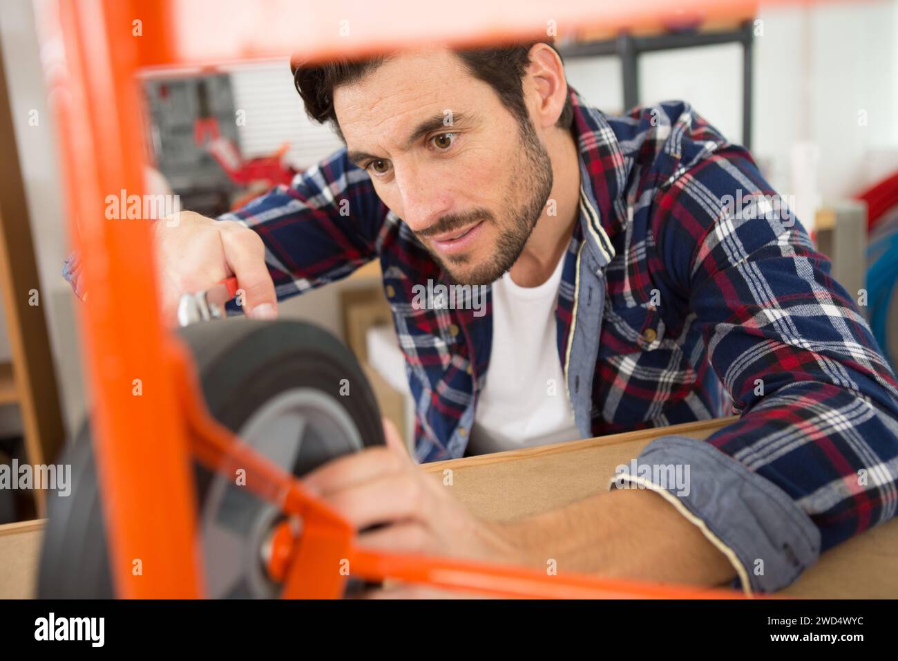 worker fixing sack truck wheel Stock Photo - Alamy