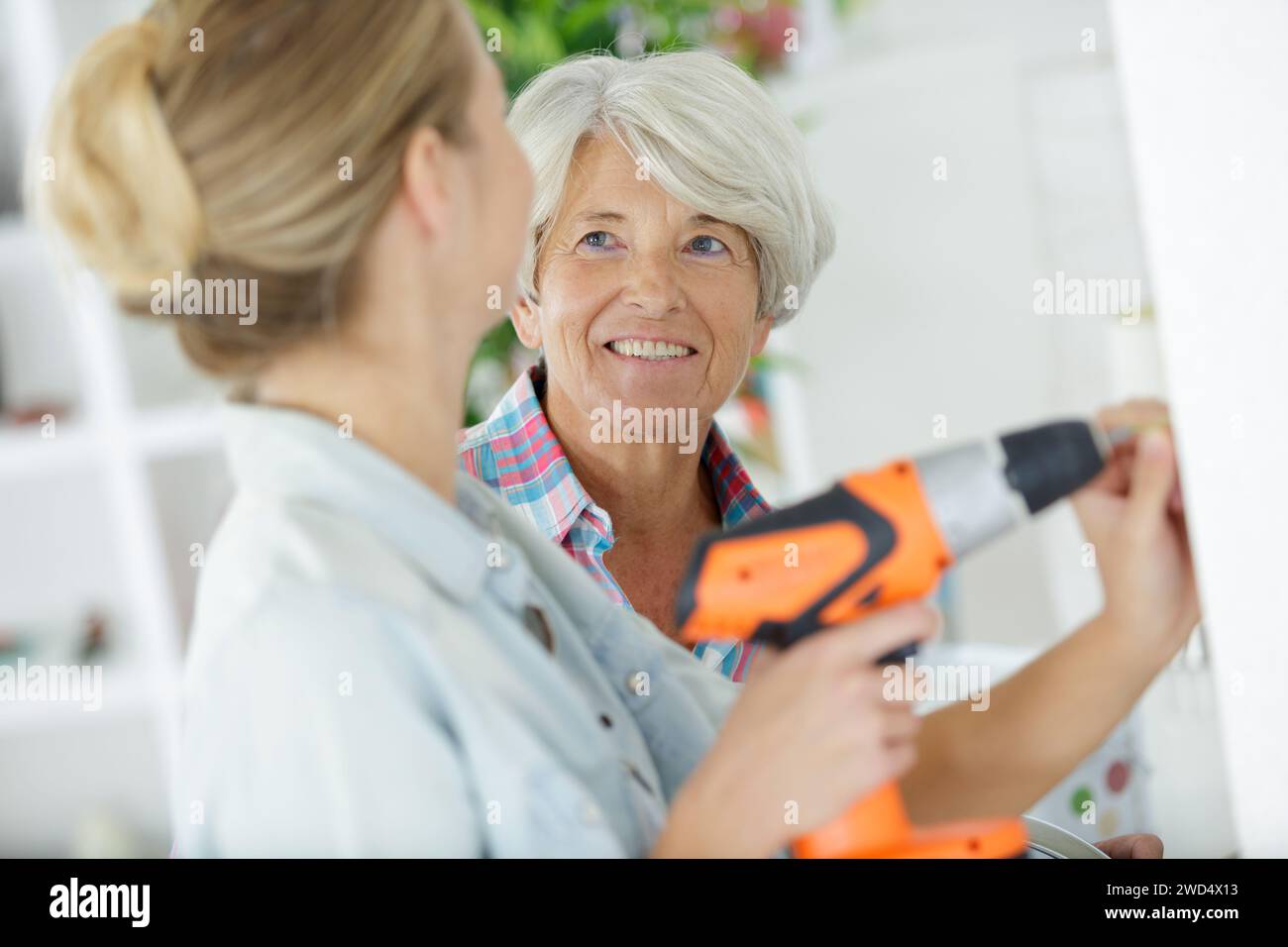 smiling daughter and grandmother working together Stock Photo - Alamy