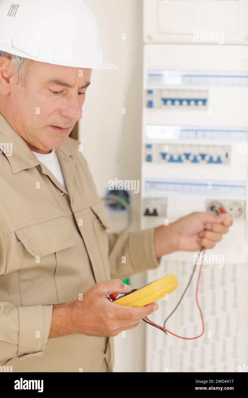 electrician measures the voltage of a residential electrical ...