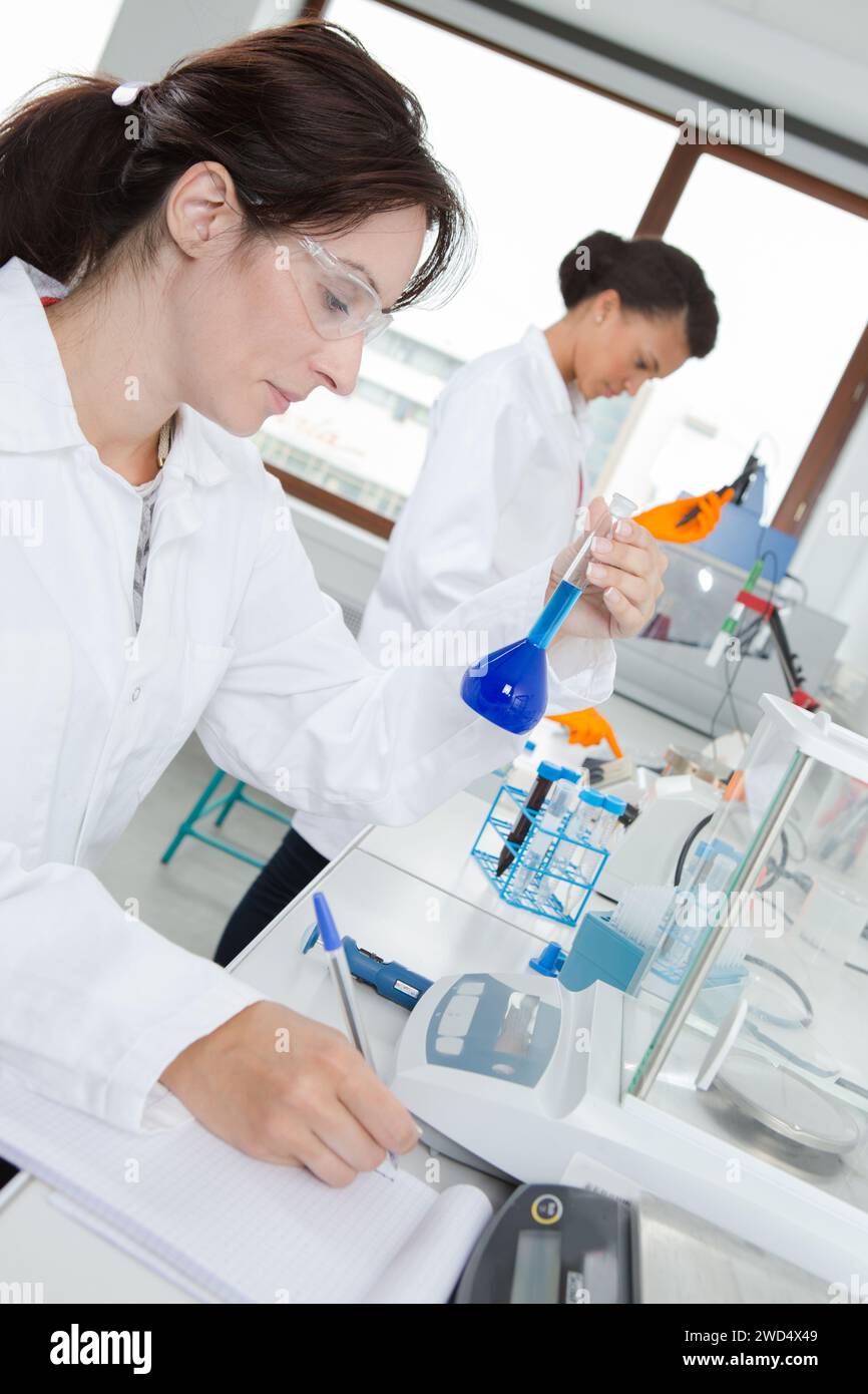 beautiful lab worker holding up test tube Stock Photo - Alamy