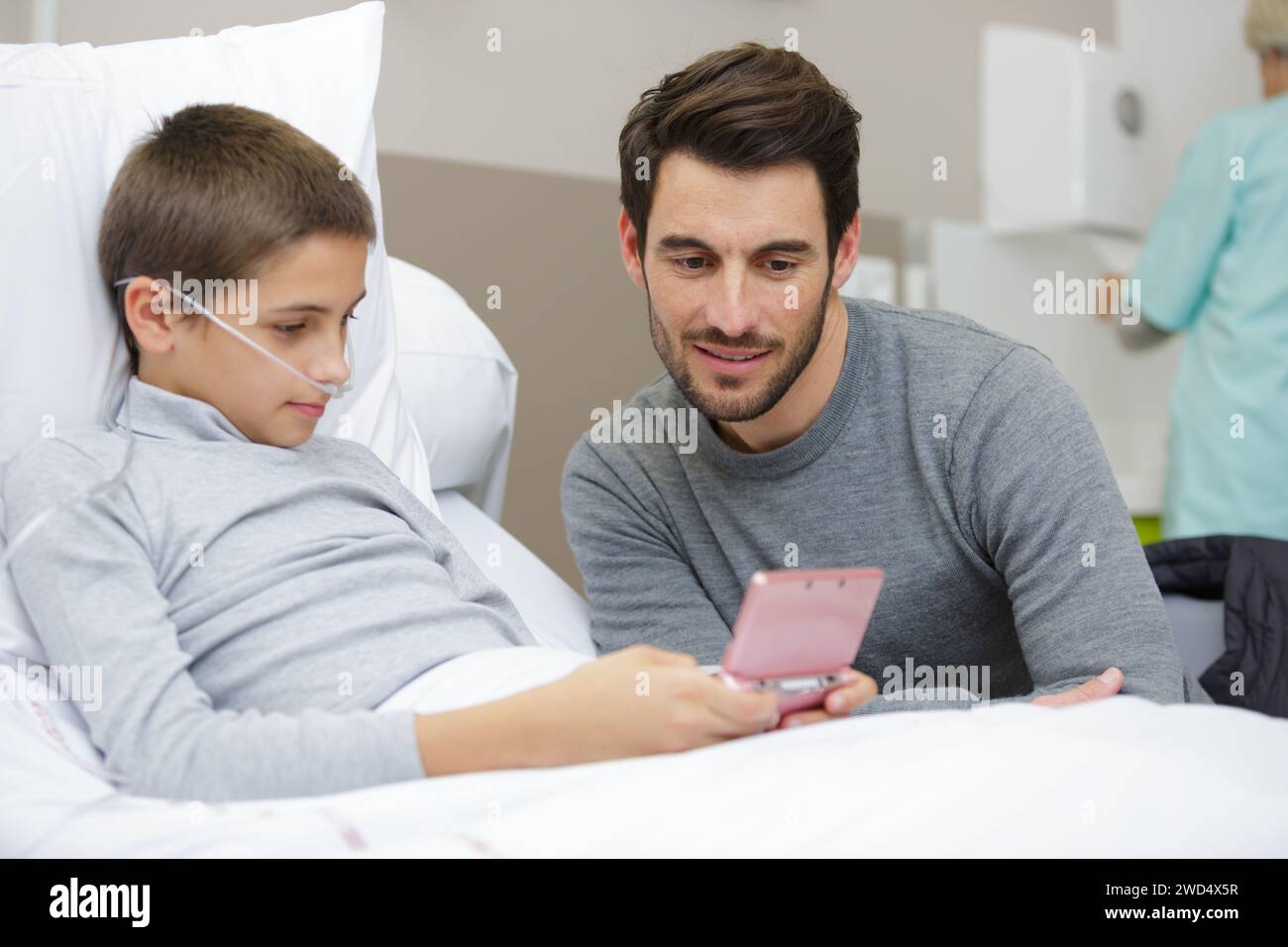 father taking care of son in the hospital Stock Photo - Alamy