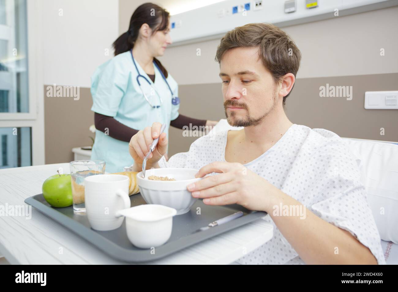 male patient eating meal in hospital bed Stock Photo - Alamy