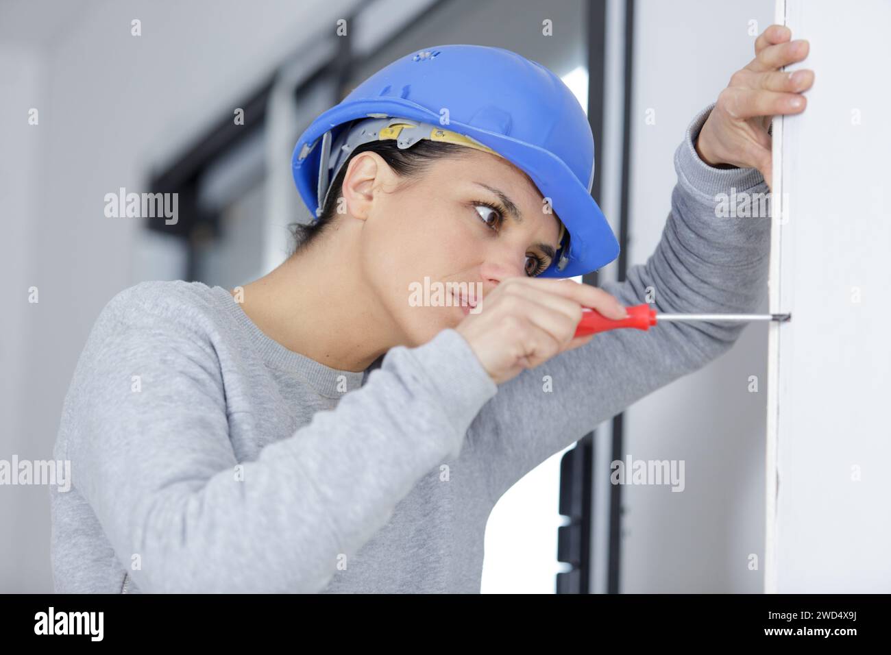 woman installing window handle with screwdriver Stock Photo - Alamy