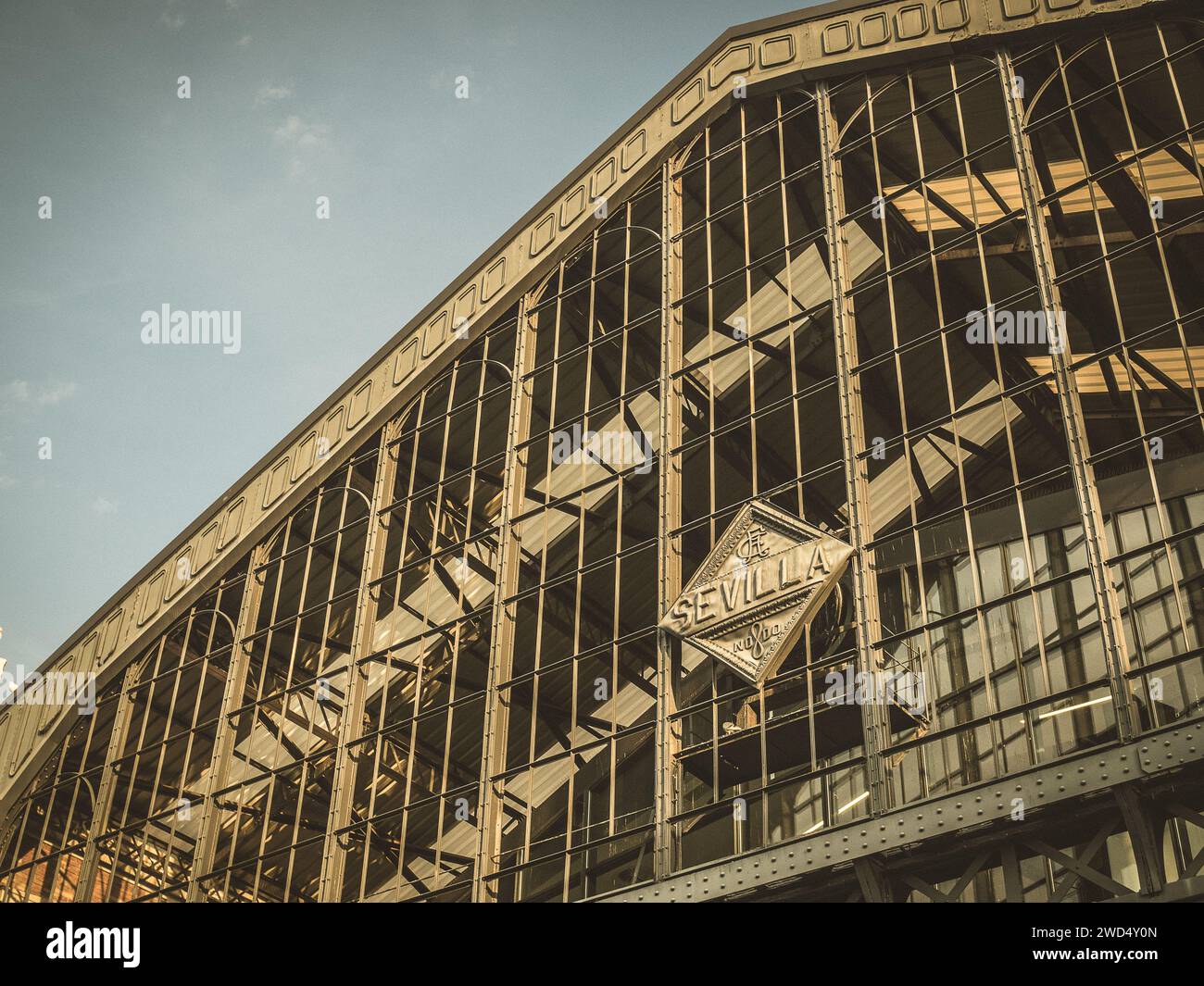 A towering building with multiple glass walls and a clock situated atop ...