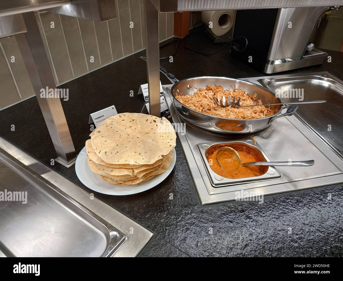 A tray containing freshly made tortillas, a single tortilla, and a ...