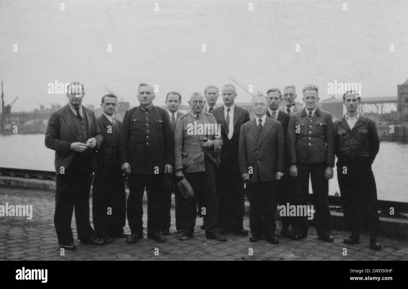 An antique photo shows a group of Caucasian men, some in uniform and ...