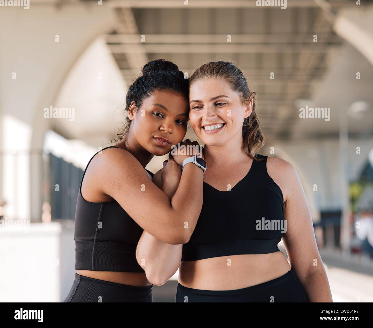 Two plus-size female friends in sportswear are standing together ...
