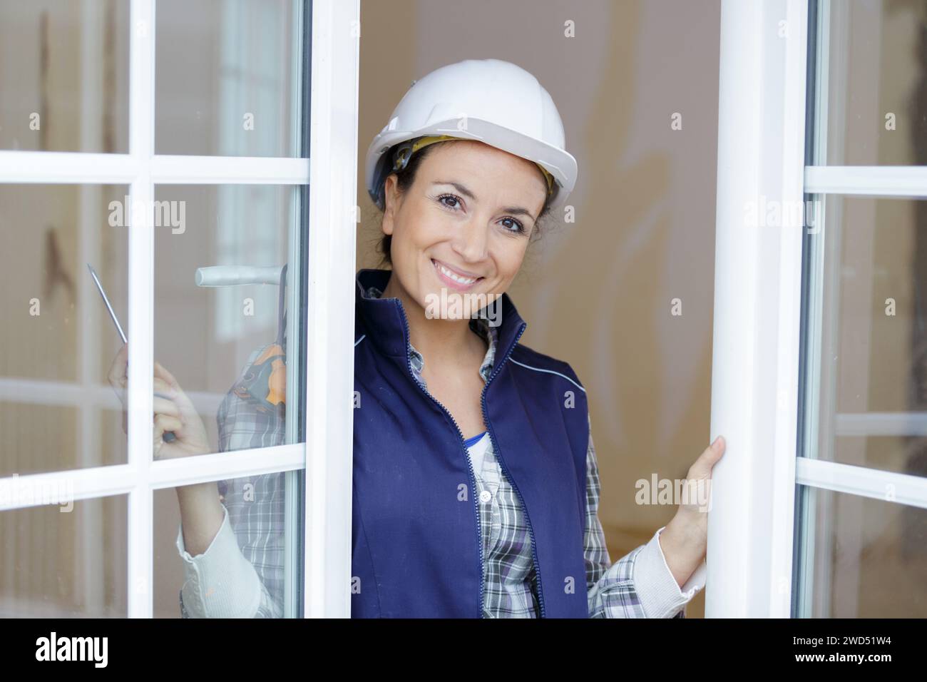 female builder fixing a window Stock Photo - Alamy