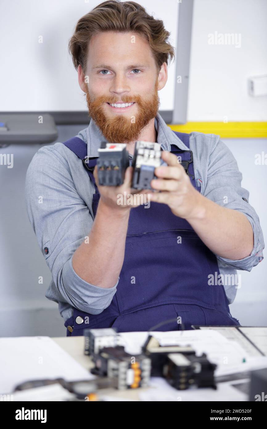 man is holding object in factory Stock Photo - Alamy