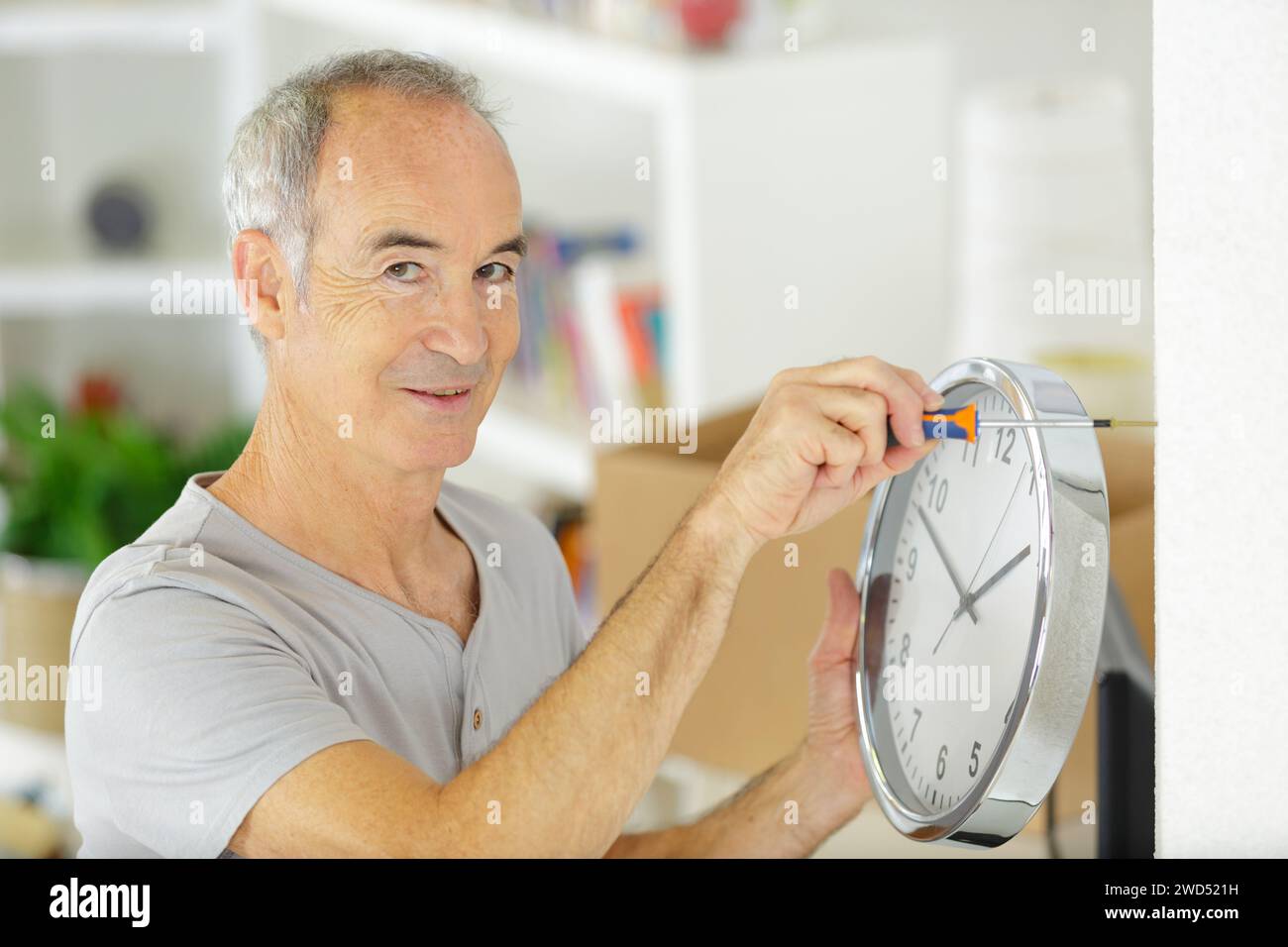 senior adjusting a clock at home Stock Photo - Alamy