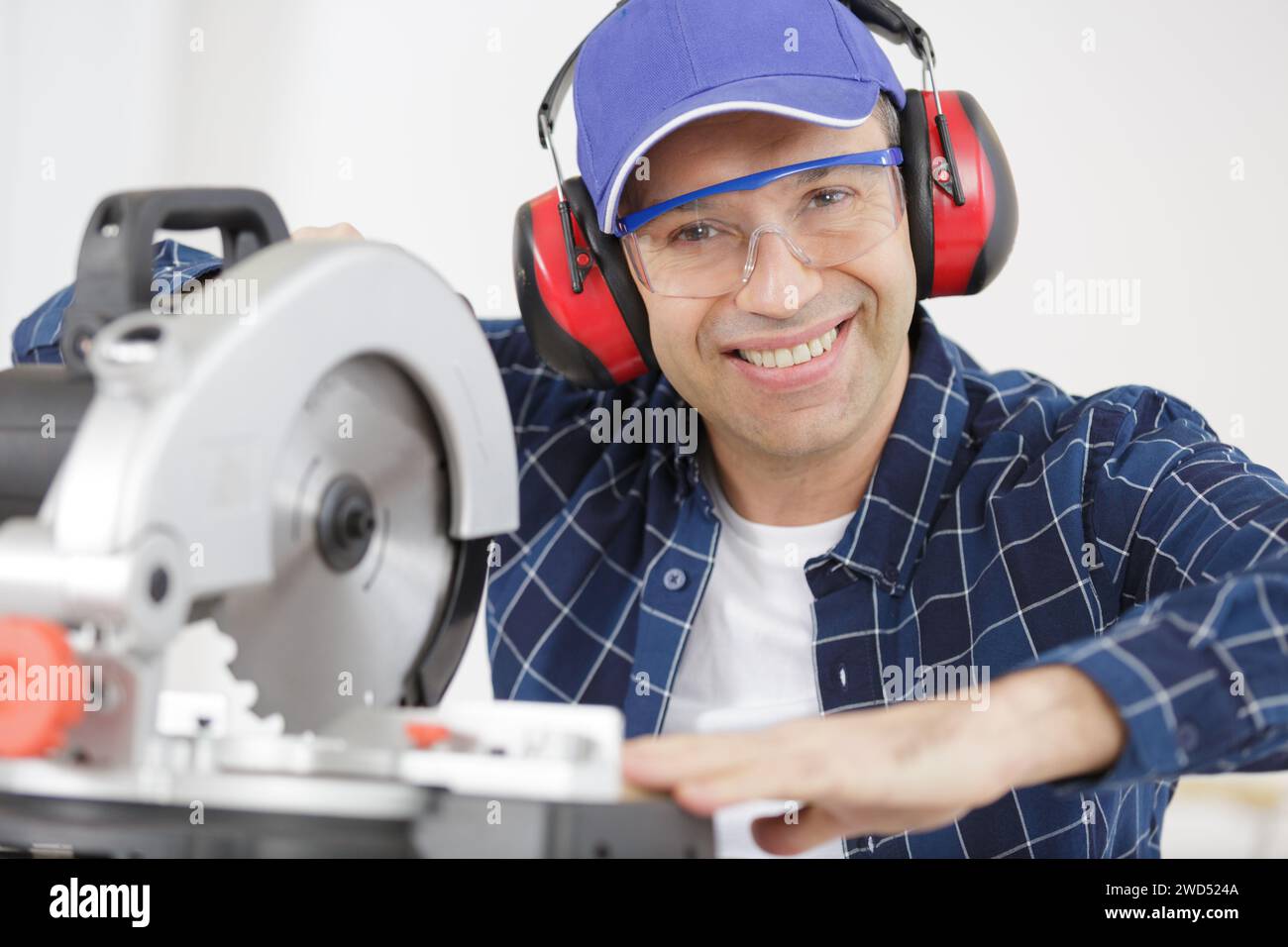 smiling older man using a circular saw Stock Photo - Alamy