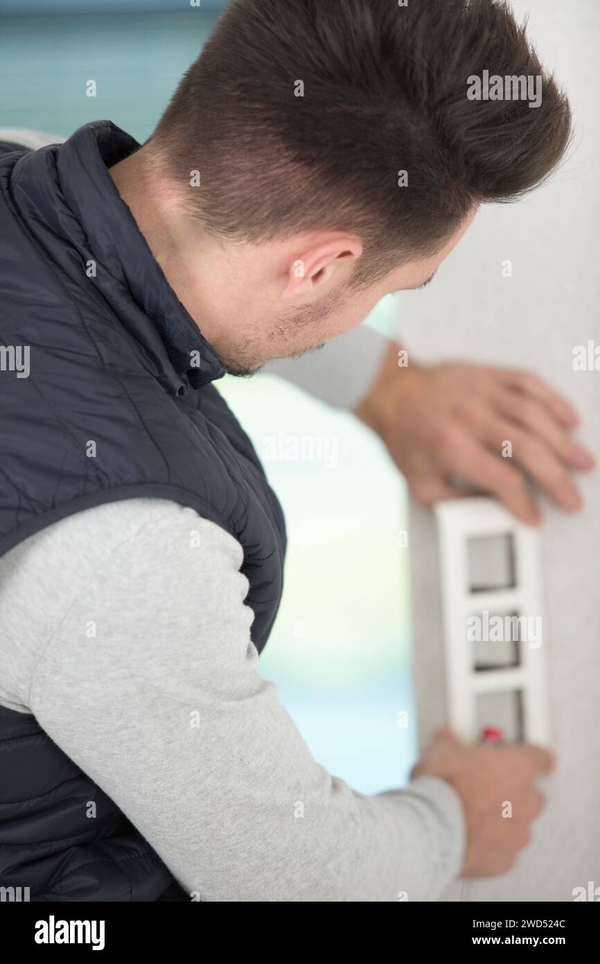 adult electrician man installing plug into a wall Stock Photo - Alamy