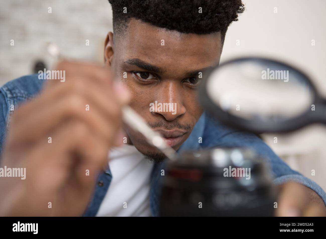 technician examining camera lens thorugh a magnifying glass Stock Photo ...