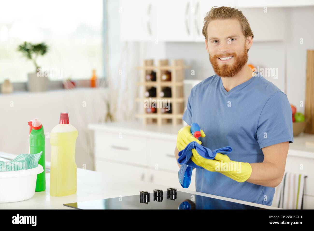 male janitor cleaning kitchen counter with detergent spray Stock Photo ...