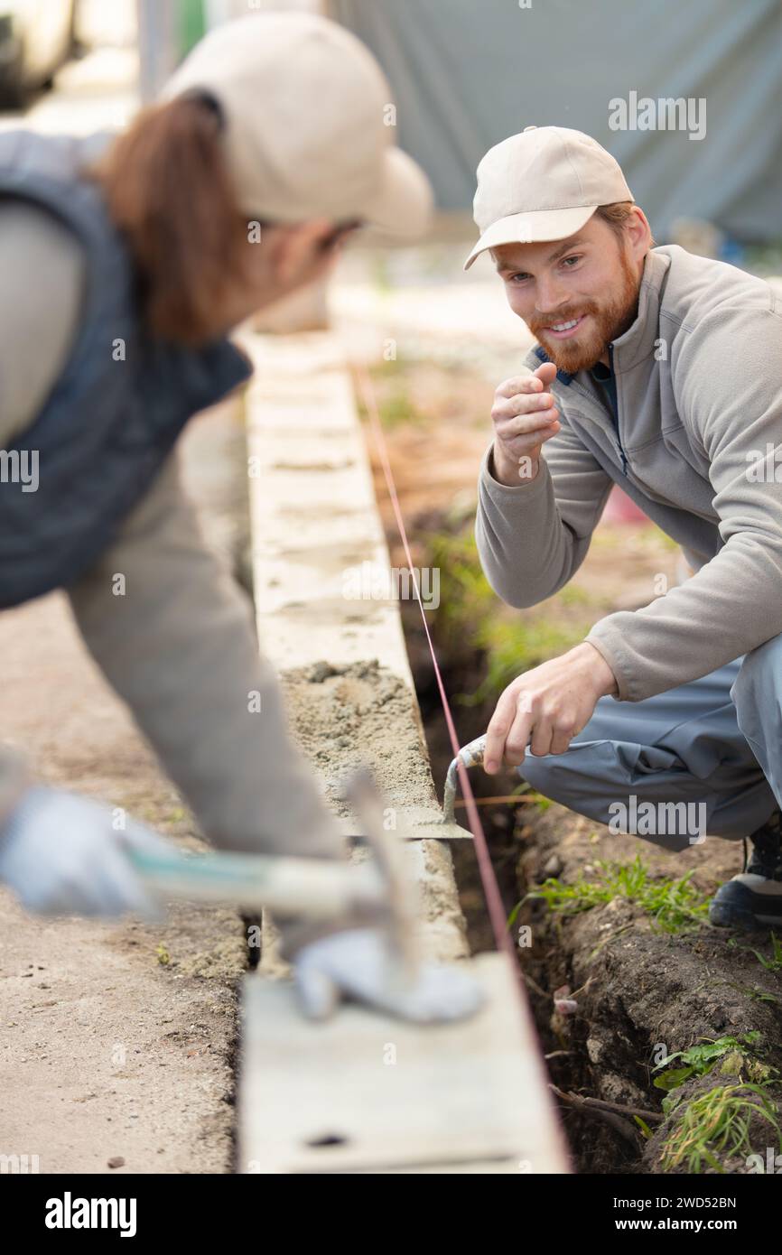 builders building a cement wall Stock Photo - Alamy