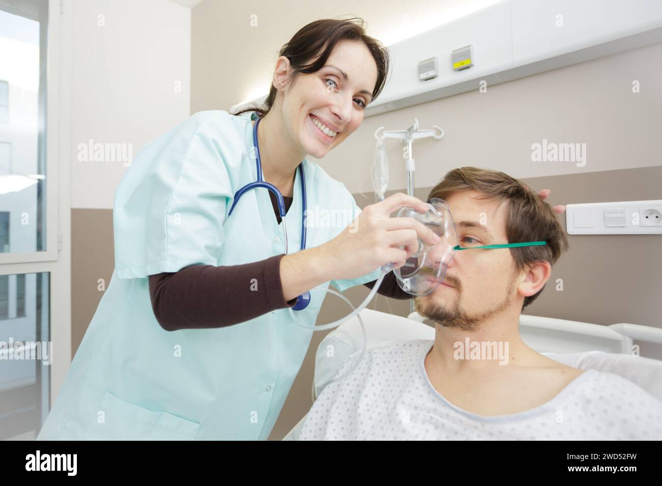 happy nurse placing oxygen mask on patient Stock Photo - Alamy