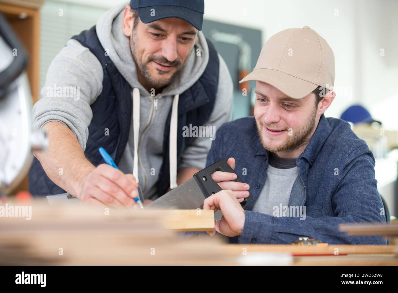 portrait of carpenter cutting wood while working in joinery workshop ...