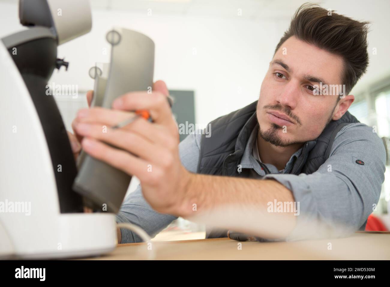 professional young worker fixing a coffee maker Stock Photo - Alamy