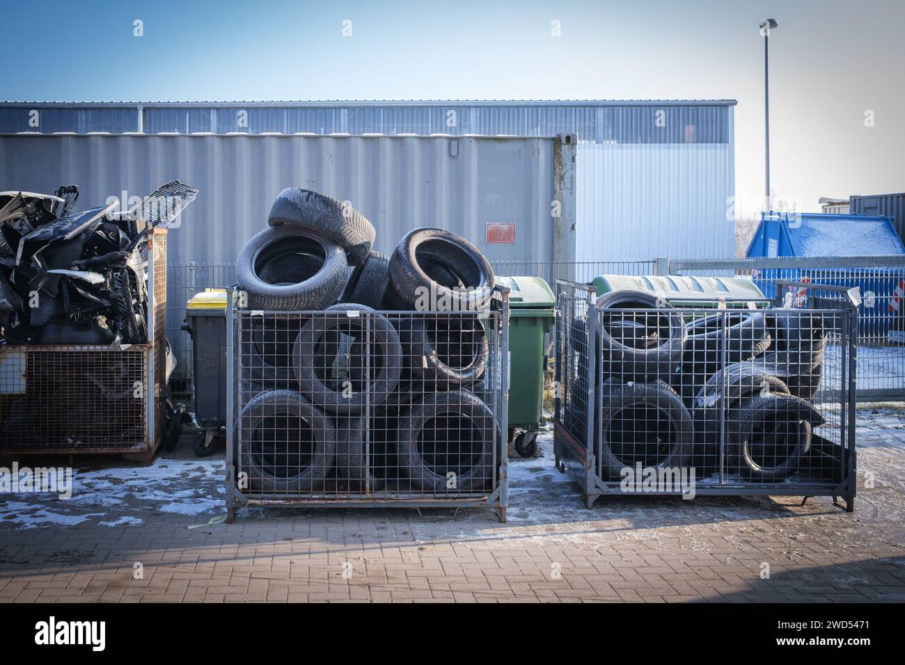 some containers filled with old tires and car parts in the yard of a ...