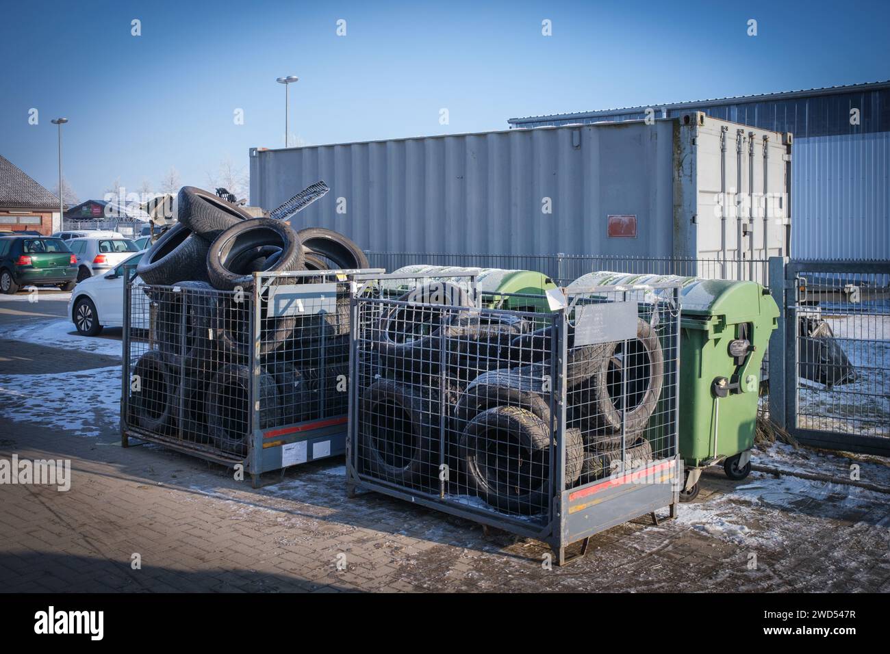some containers filled with old tires and car parts in the yard of a ...