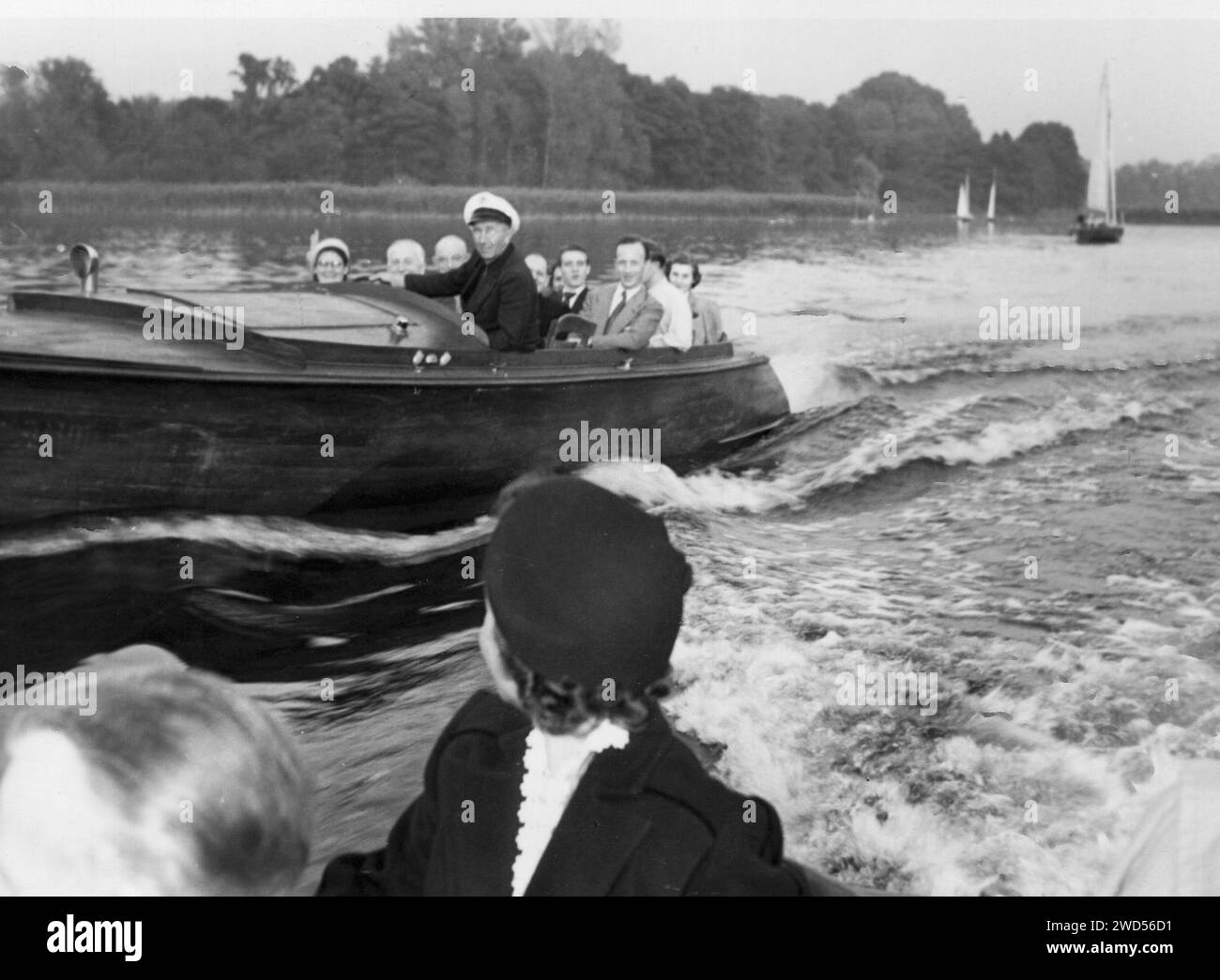 An antique photo with shows a woman in a beret sitting on the stern of ...