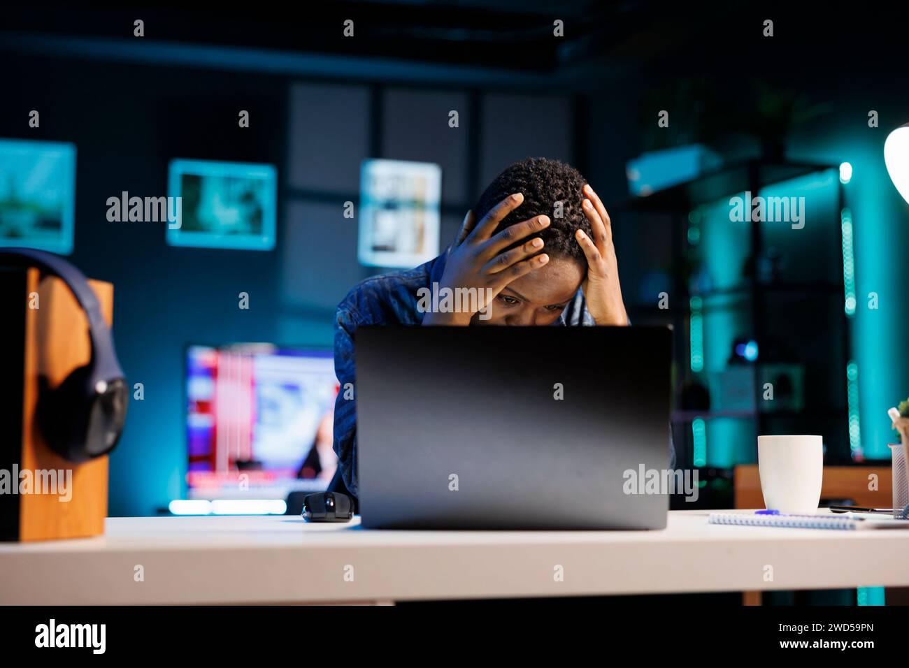 Frustrated african american woman with hands on head, sitting in front ...