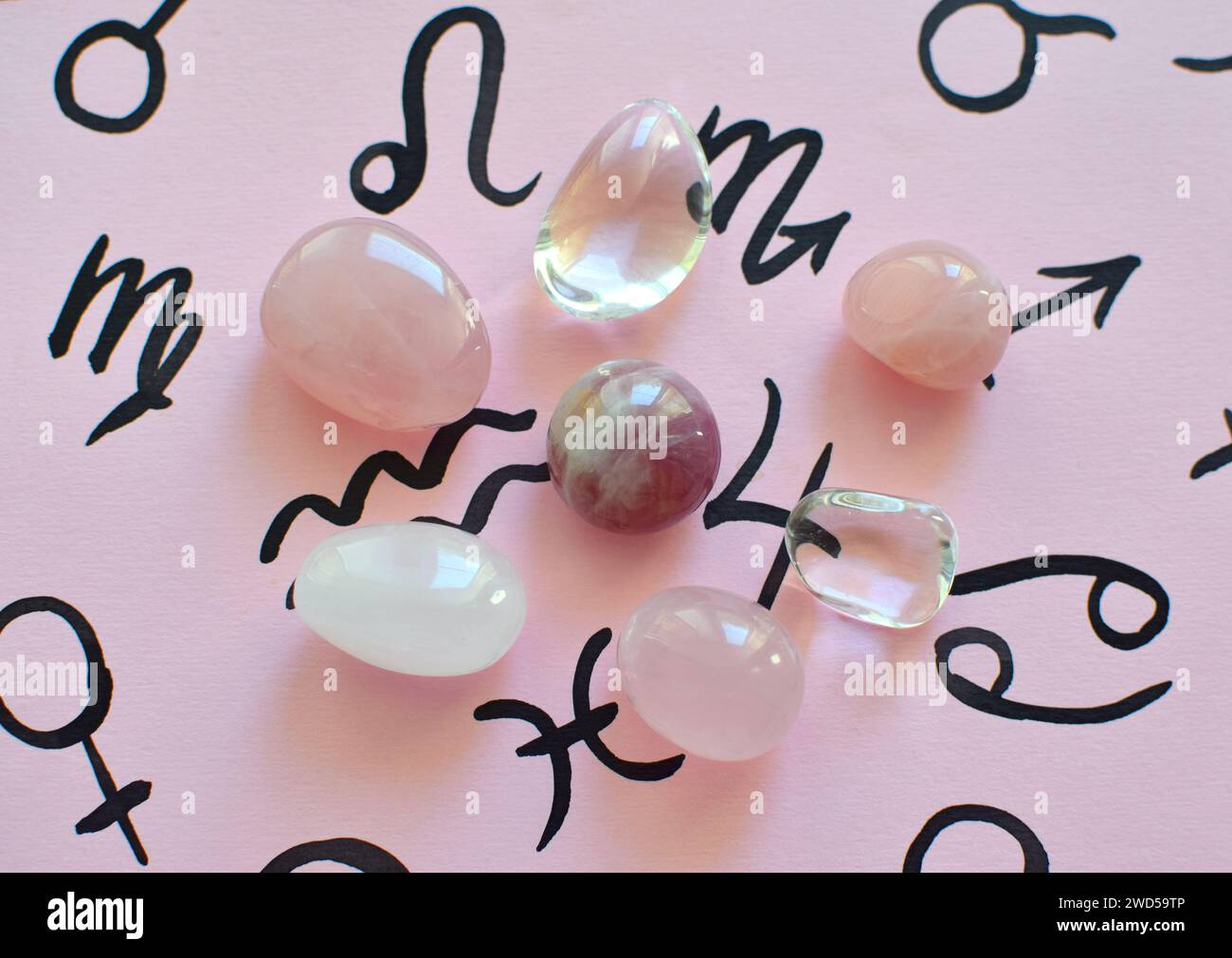 Beautiful crystals and rose quartz on a pink background with symbols of ...