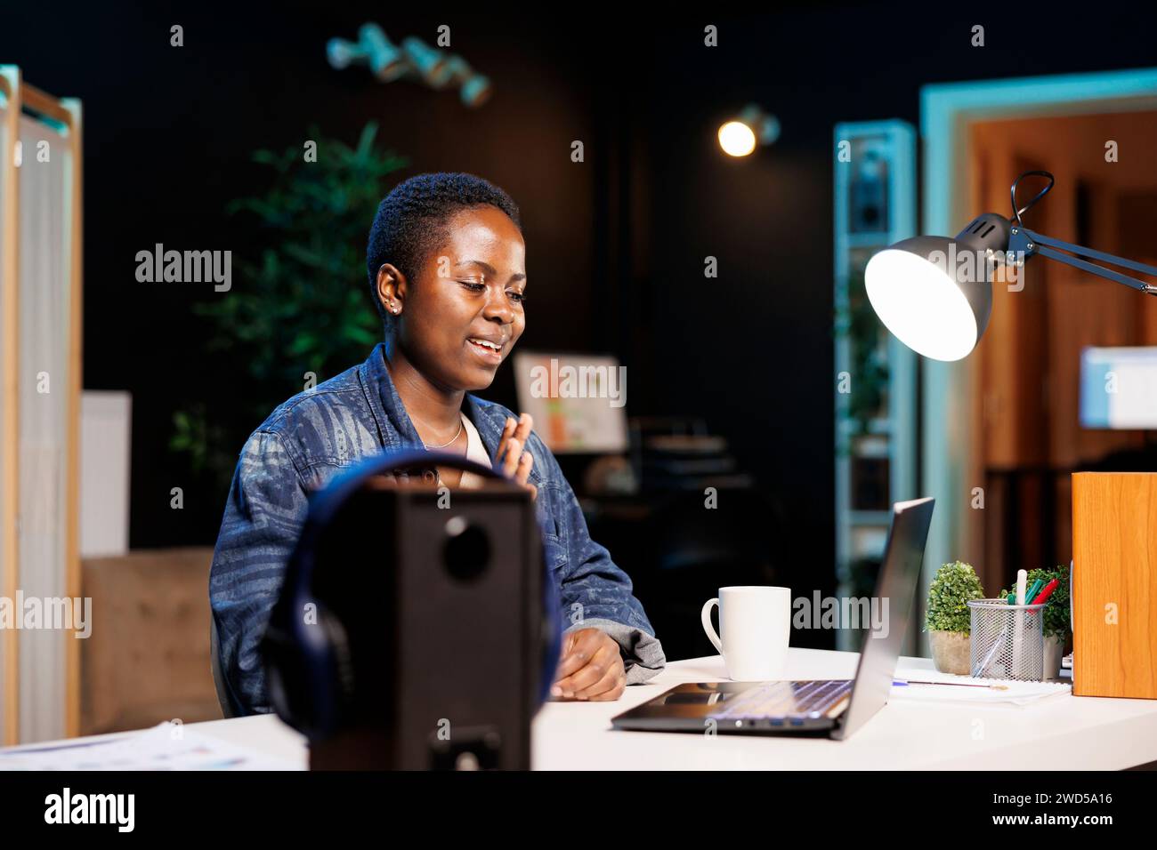 Young black woman waving at laptop camera, attending online class, virtual communication with ...