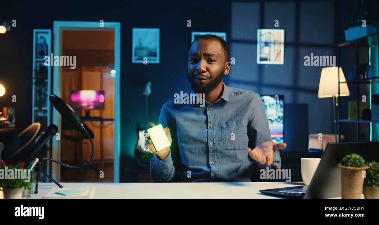 African american tech content creator filming technology review of mini ...