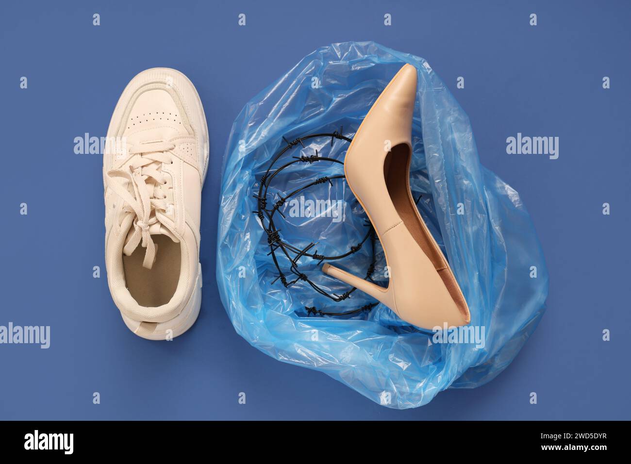 Sneaker and garbage bag with high-heeled shoe wrapped in barbed wire on ...