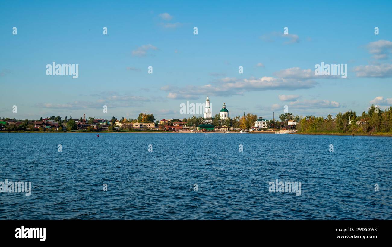a beautiful blue lake with a village and a church on the horizon Stock ...