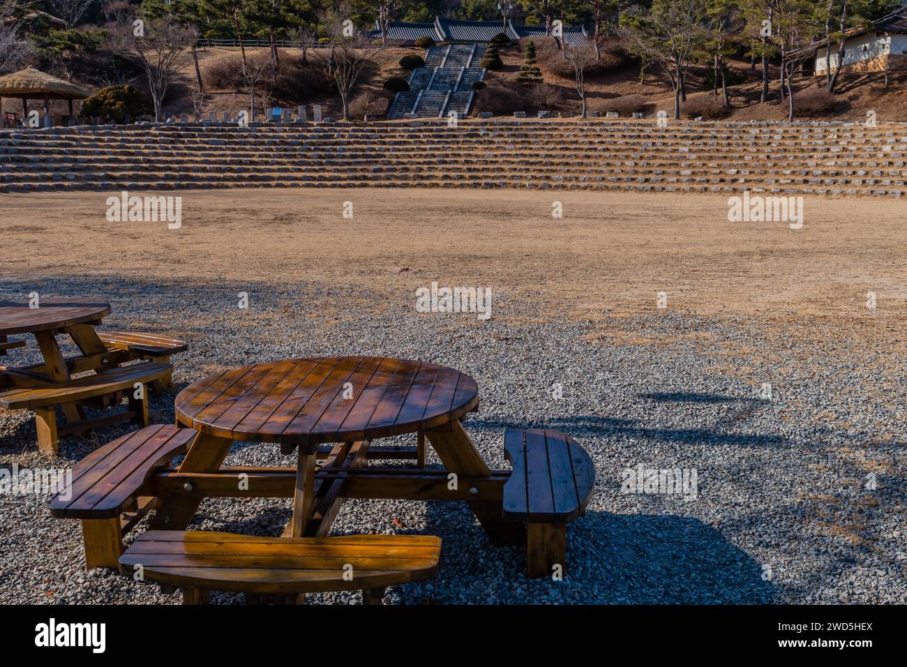 Wooden picnic table with amphitheater seating and buildings in public ...
