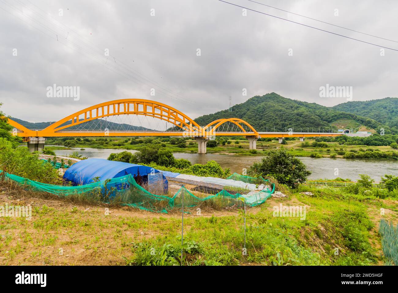 Landscape of blue tent structure surrounded by green mesh fence next to ...