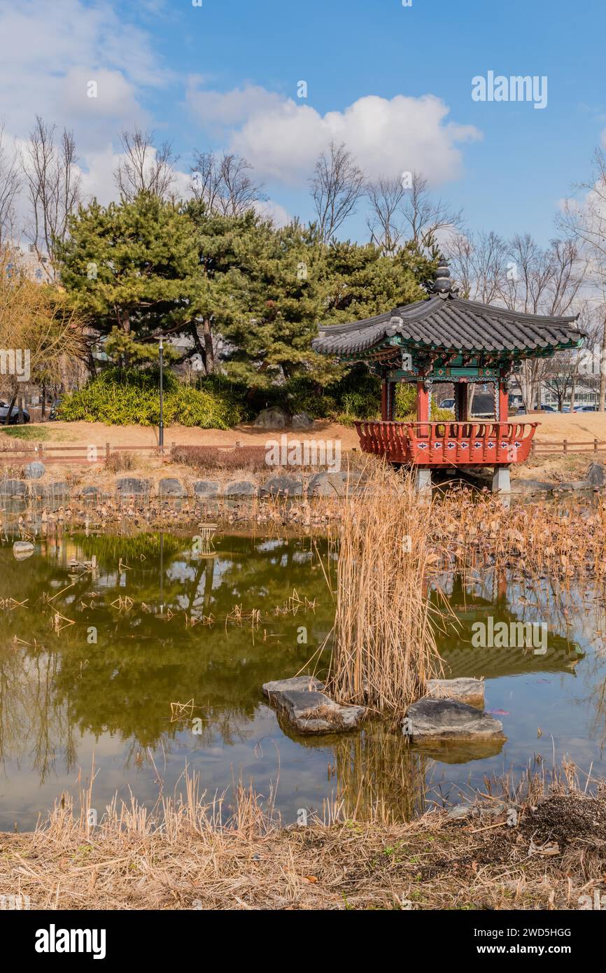Oriental gazebo on edge of small pond in urban public park on beautiful ...