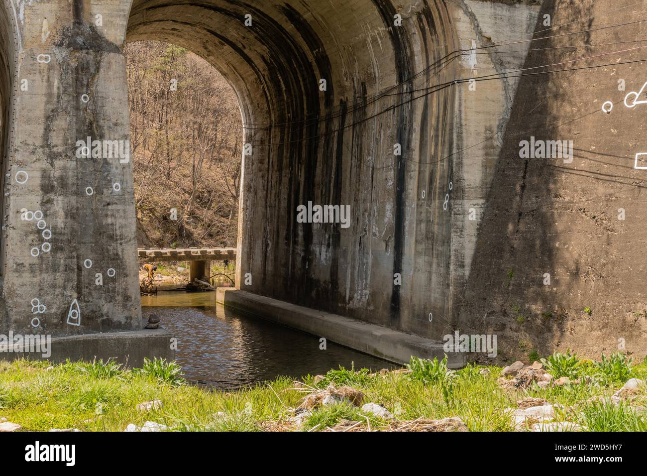 Stream running through concrete arched tunnel with white circles ...
