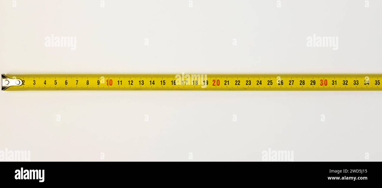 A tool for measuring length. Construction measuring tape on a white ...