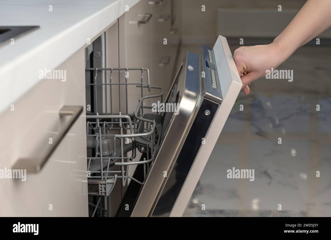 Opening and closing the dishwasher. woman's hand closes the dishwasher ...