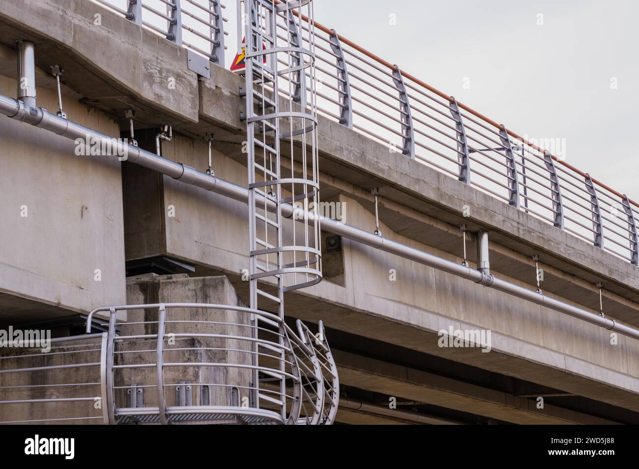 Closeup of the platform and ladder on the side of a concrete bridge ...